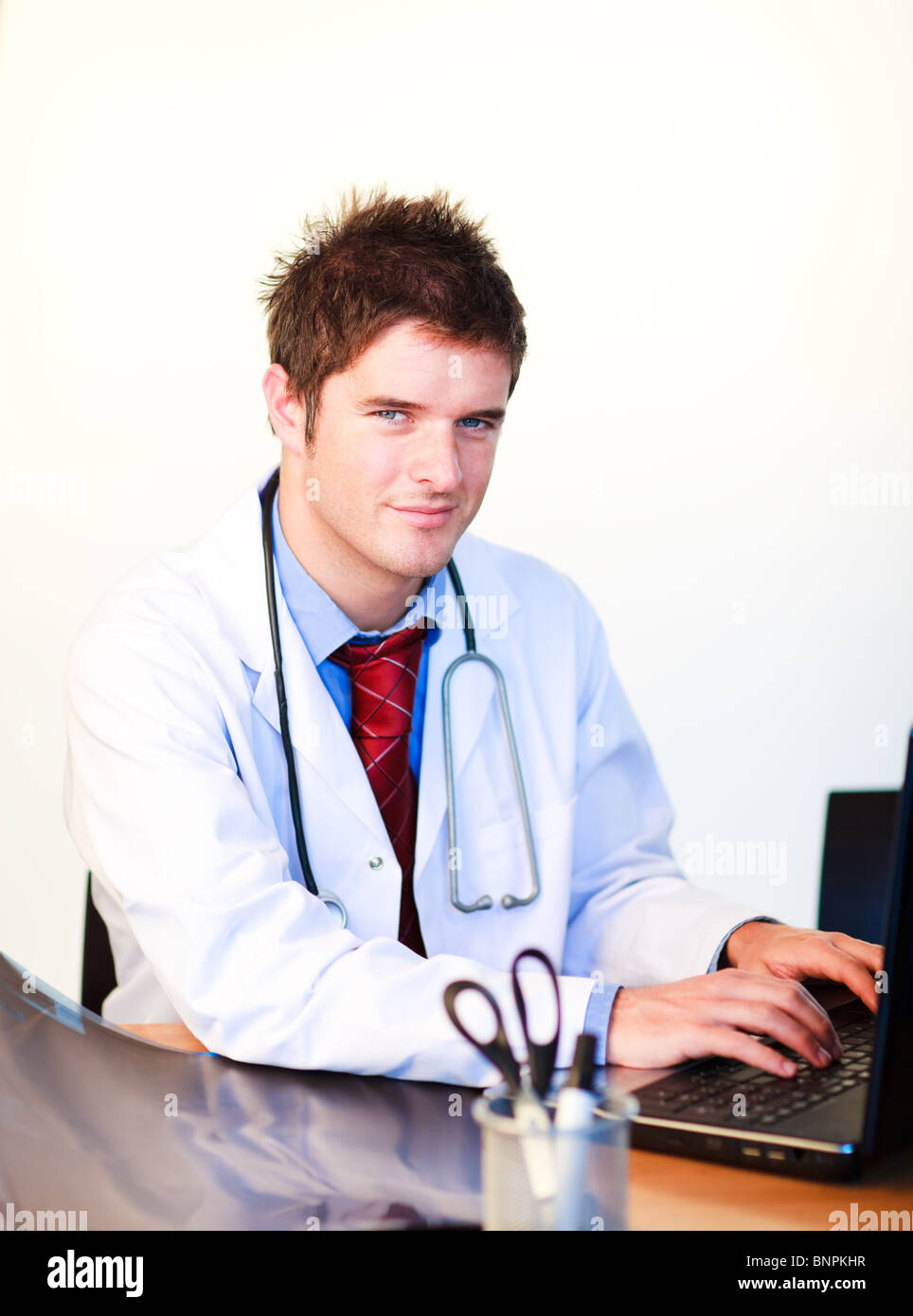 Smiling young doctor working on a computer Stock Photo - Alamy
