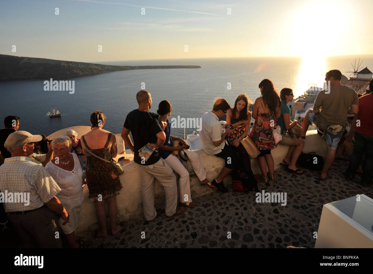 Crowds of young people gathered to see the sunset at Oia, Santorini in ...