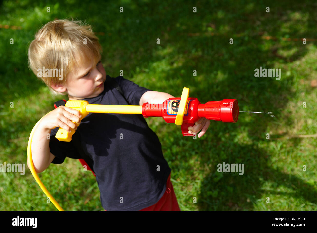 Young child boy playing fire fighter garden outside Stock Photo - Alamy