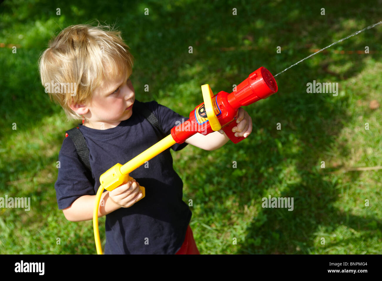 Young child boy playing fire fighter garden outside Stock Photo - Alamy