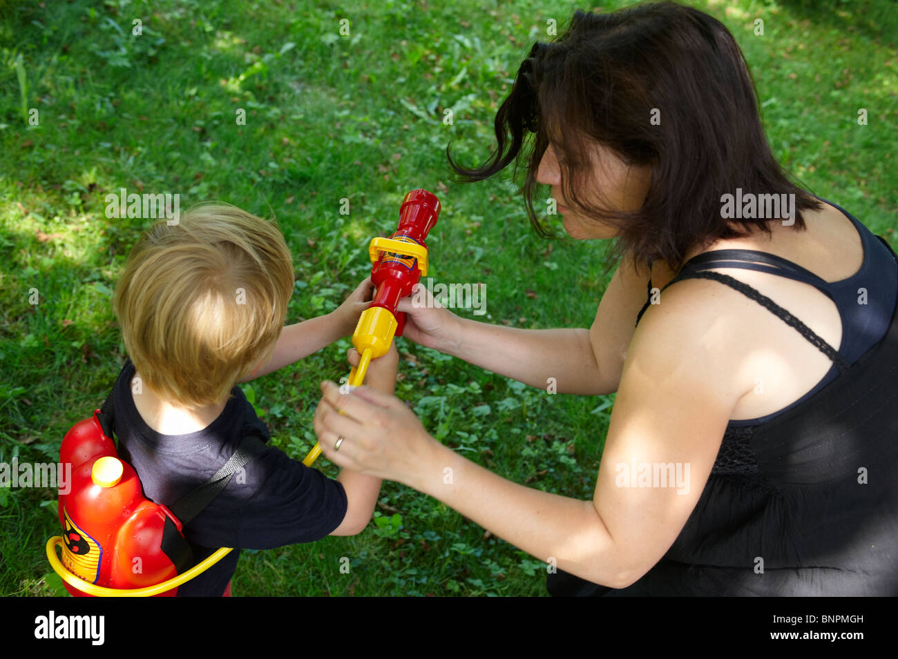 Young child boy playing fire fighter garden outside Stock Photo - Alamy