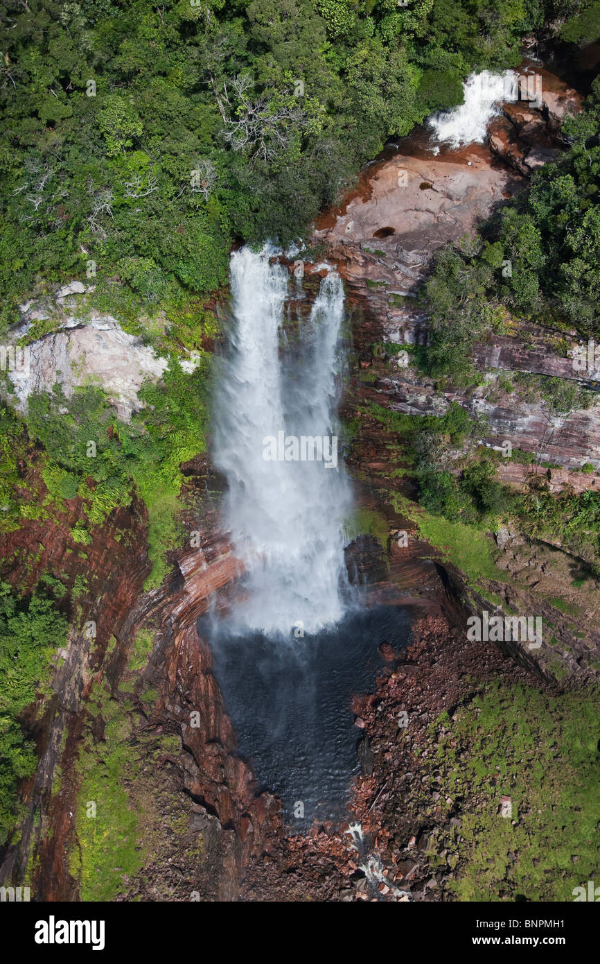 Aerial view of waterfall cascading over the side of sandstone cliffs of ...