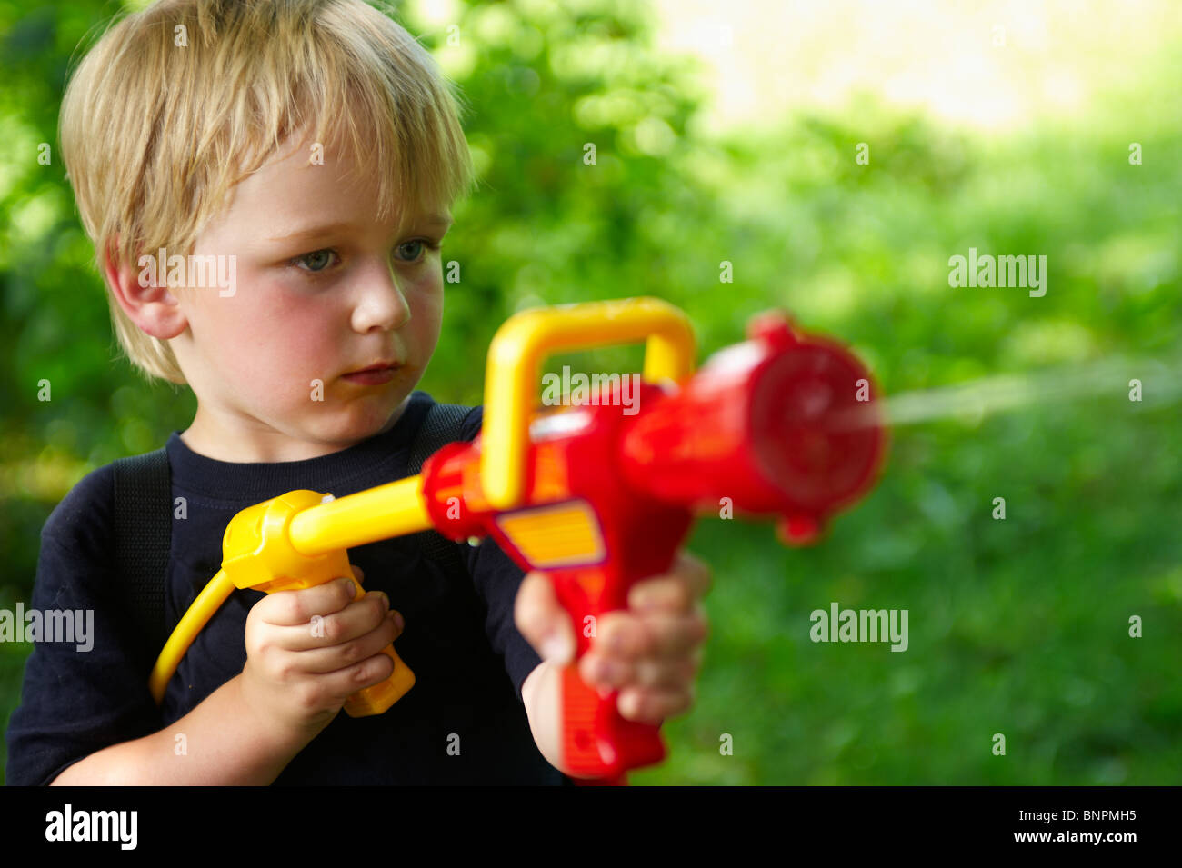 Young child boy playing fire fighter garden outside Stock Photo - Alamy