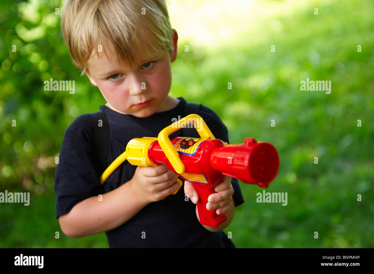 Young child boy playing fire fighter garden outside Stock Photo - Alamy