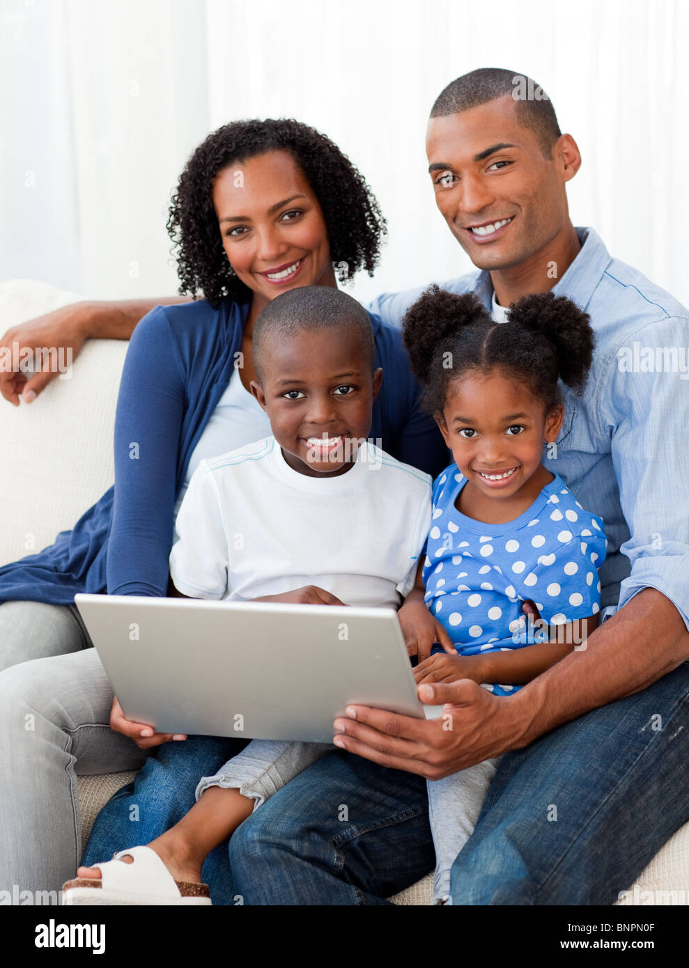 Smiling family using a laptop Stock Photo - Alamy