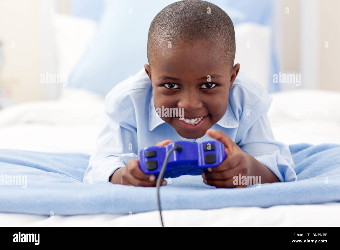 Smiling little boy playing video game Stock Photo - Alamy