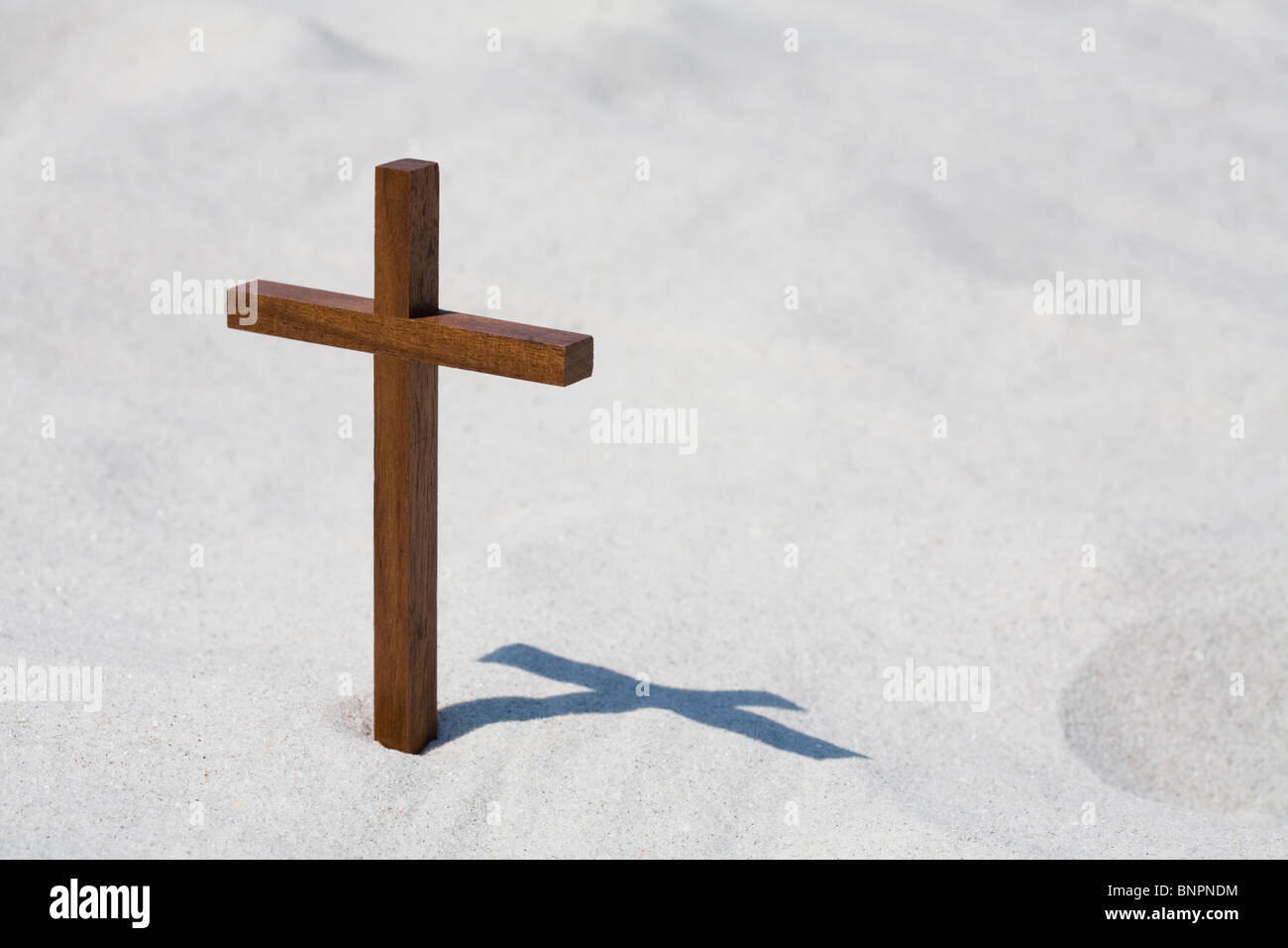 A cross in the sand with shadow Stock Photo - Alamy