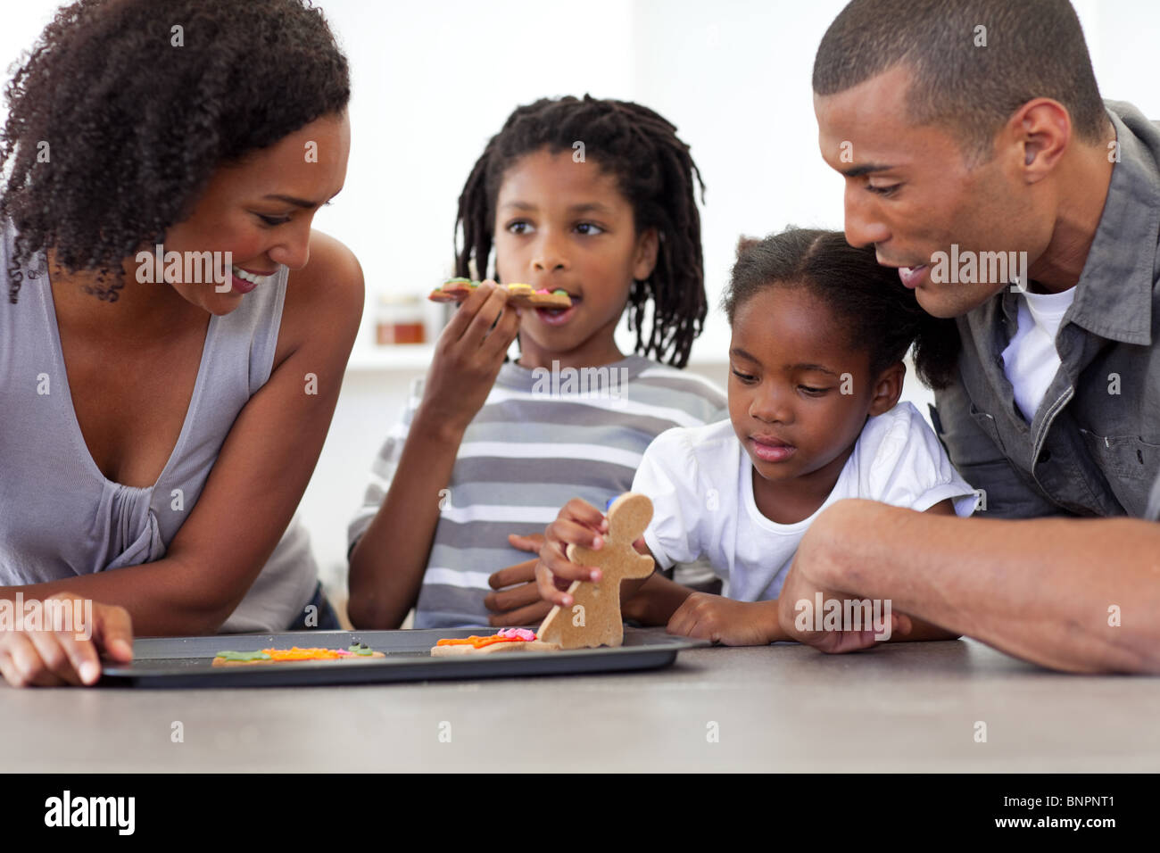 Happy family eating homemade biscuits Stock Photo - Alamy