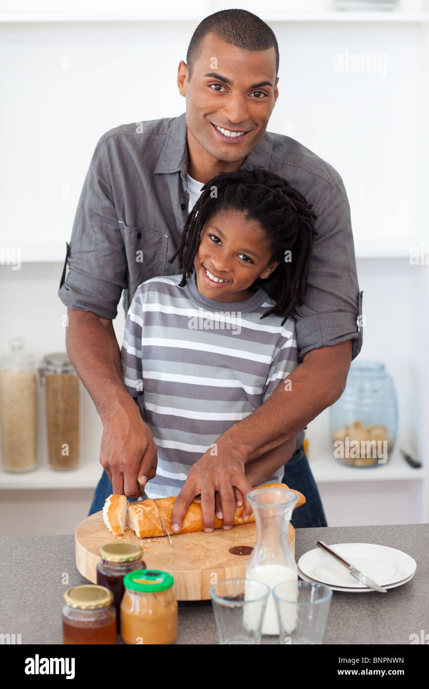 Smiling father and his son cutting bread Stock Photo - Alamy