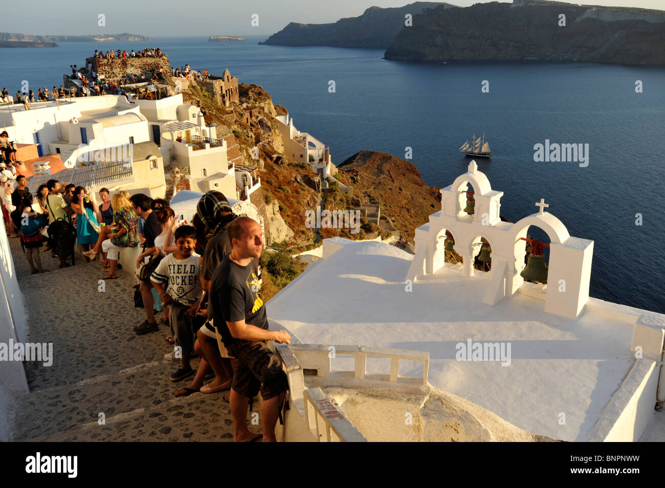 Crowds of young people gathered to see the sunset at Oia, Santorini in ...