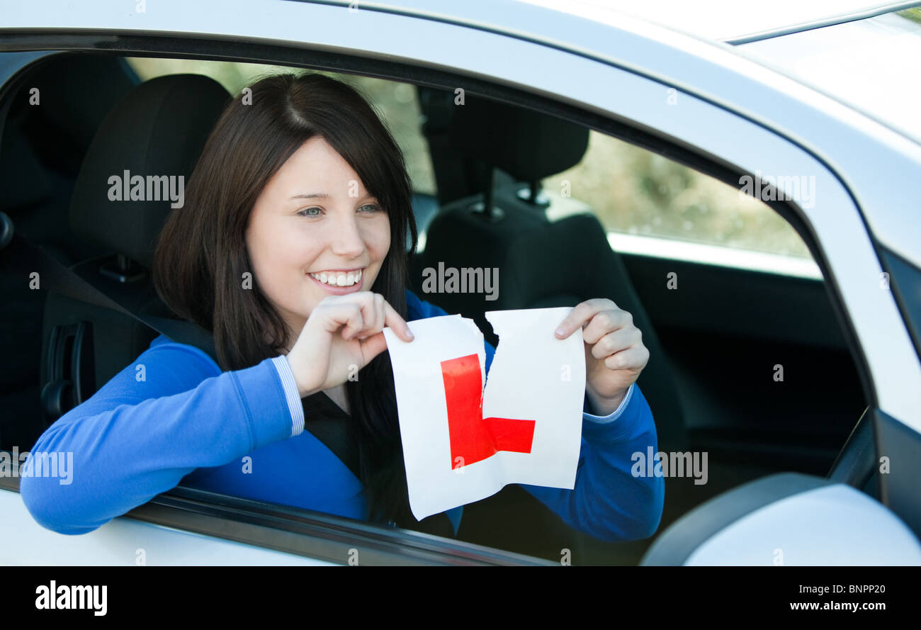 Joyful teen girl sitting in her car tearing a L-sign Stock Photo - Alamy