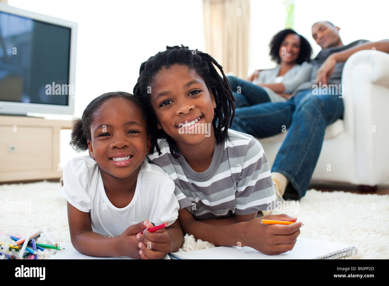 Jolly siblings playing lying on the floor Stock Photo - Alamy