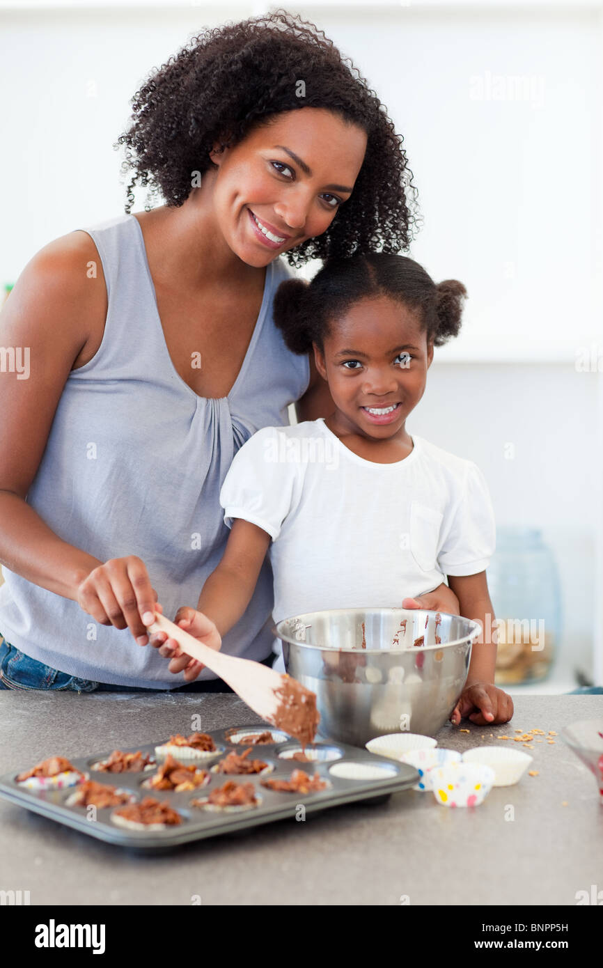 Attentive mother helping her girl cooking biscuits Stock Photo - Alamy