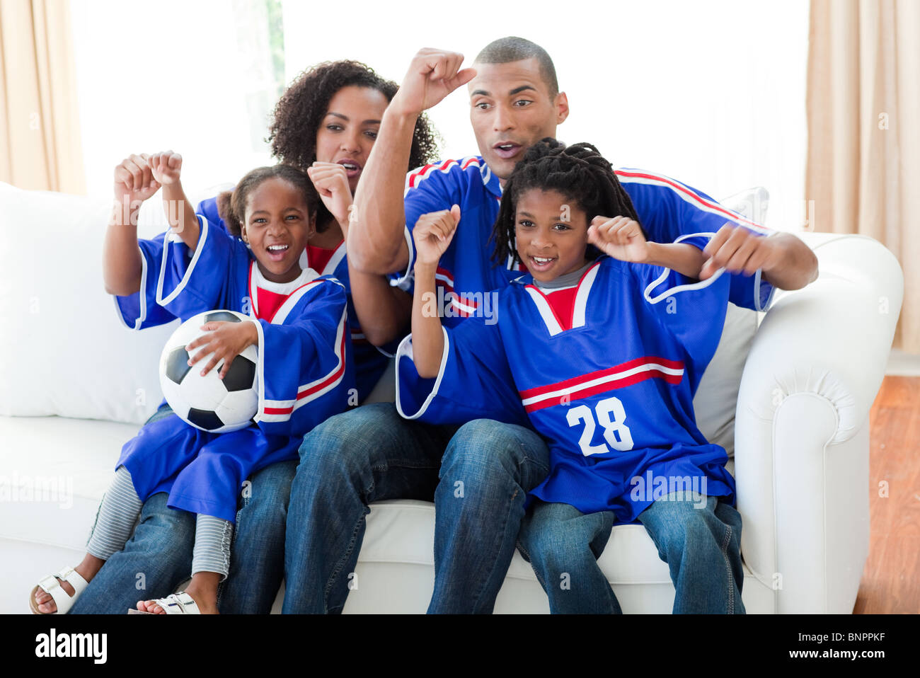 Family celebrating a goal at home Stock Photo - Alamy