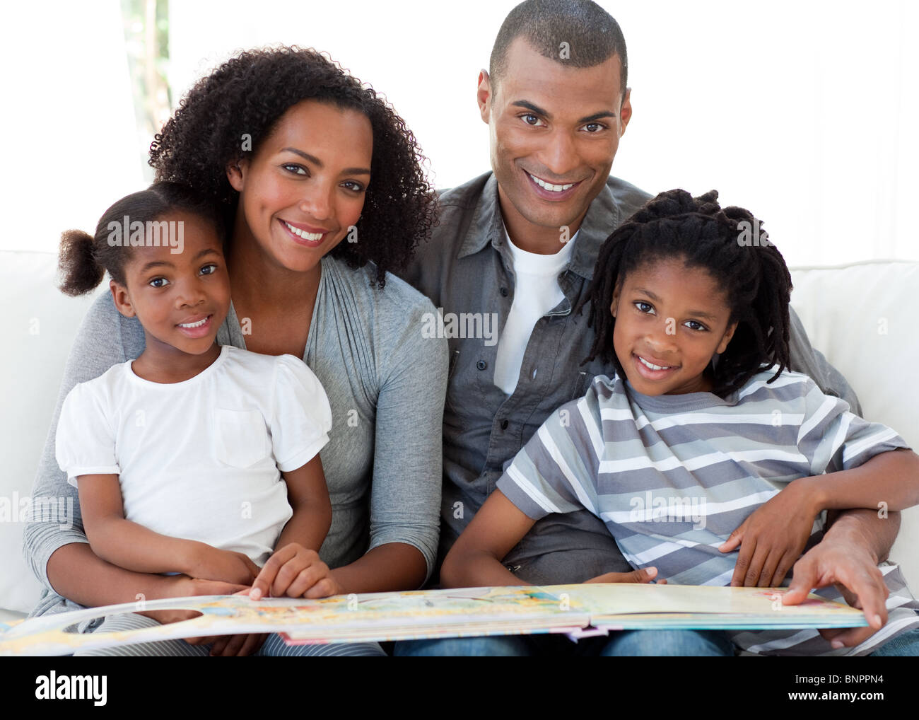 Portrait of an family reading a book in the living-room Stock Photo - Alamy