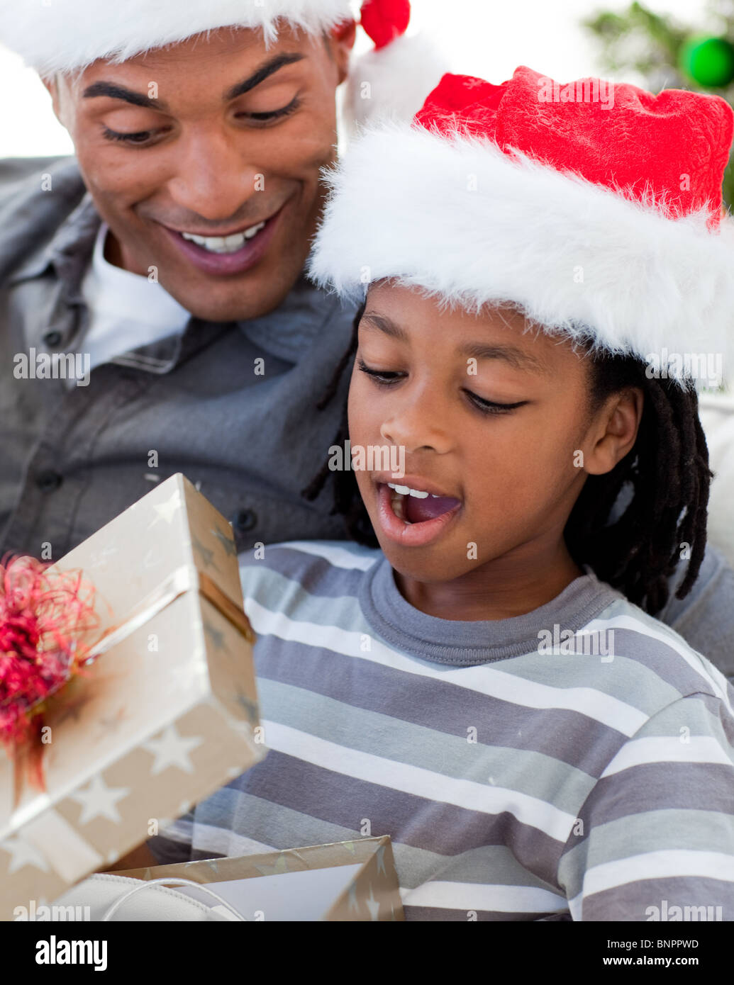 Portrait of an father and son opening a Christmas gift Stock Photo - Alamy