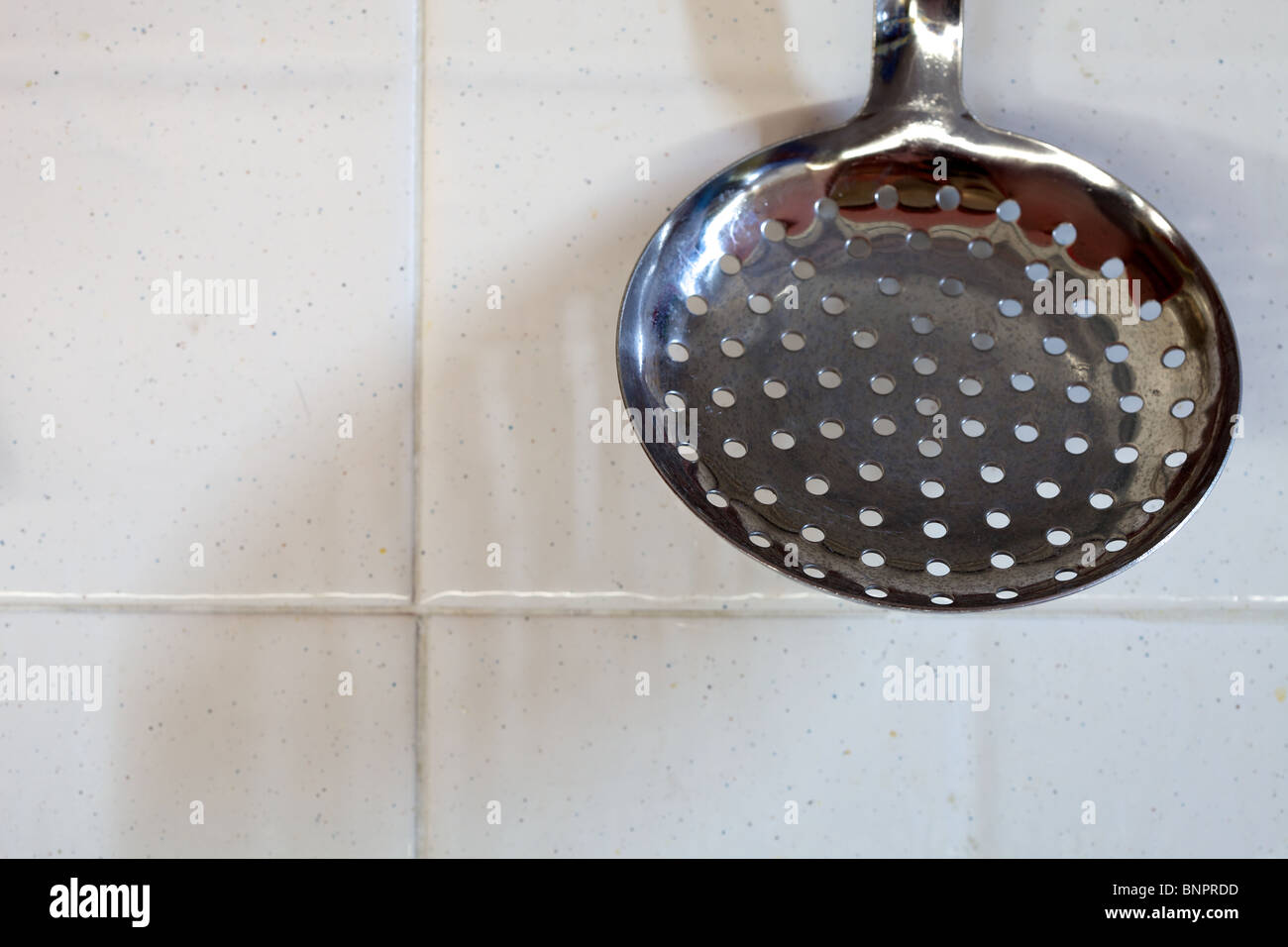 Kitchen Utensils on white tile Stock Photo - Alamy