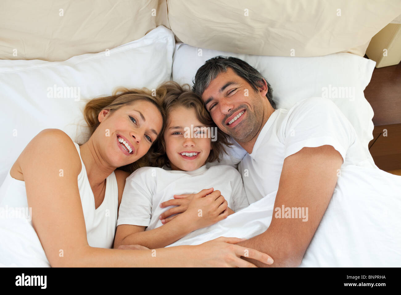 Affectionate parents hugging their son Stock Photo - Alamy