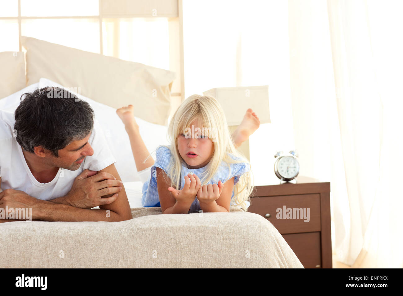 Adorable child having discussion with her father Stock Photo - Alamy
