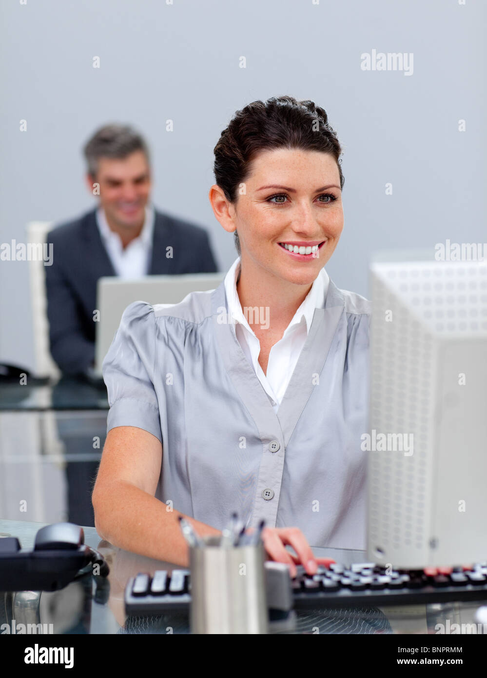 Smiling business woman working at a computer Stock Photo - Alamy