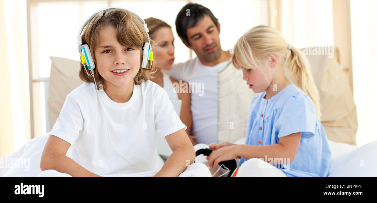 Smiling siblings listening music with headphones Stock Photo - Alamy