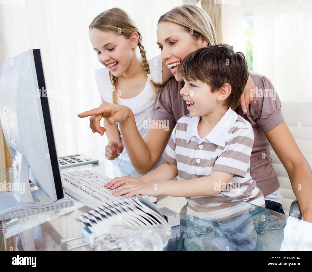 Children and their mother using a computer Stock Photo - Alamy