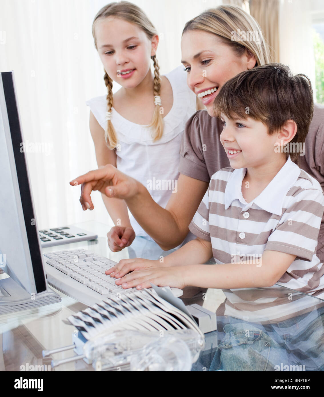 Happy mother and her children using a computer Stock Photo - Alamy