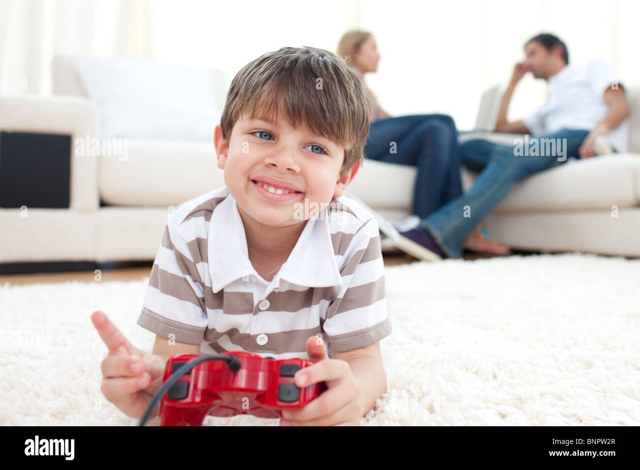 Smiling little boy playing video games Stock Photo - Alamy