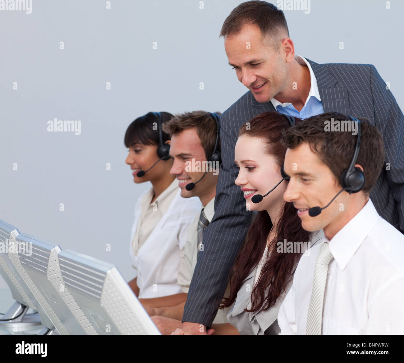 Attractive manager checking his team work in a call center Stock Photo ...