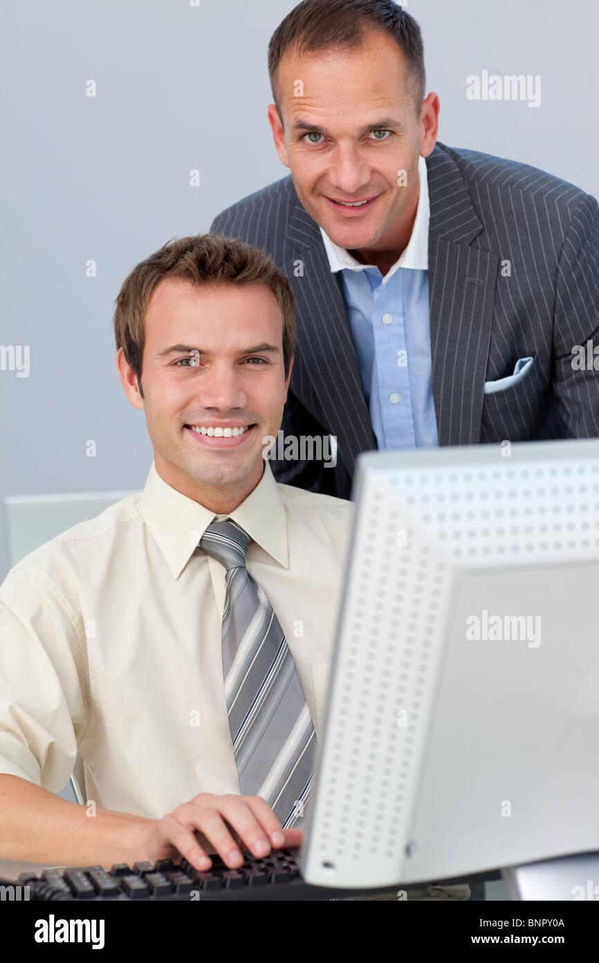 Assertive business partners working together at a computer Stock Photo ...