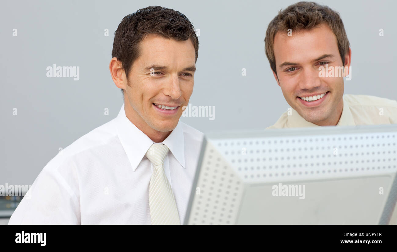 Two businessmen working together at a computer Stock Photo - Alamy