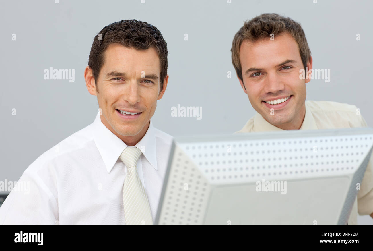 Smiling businessmen working together at a computer Stock Photo - Alamy