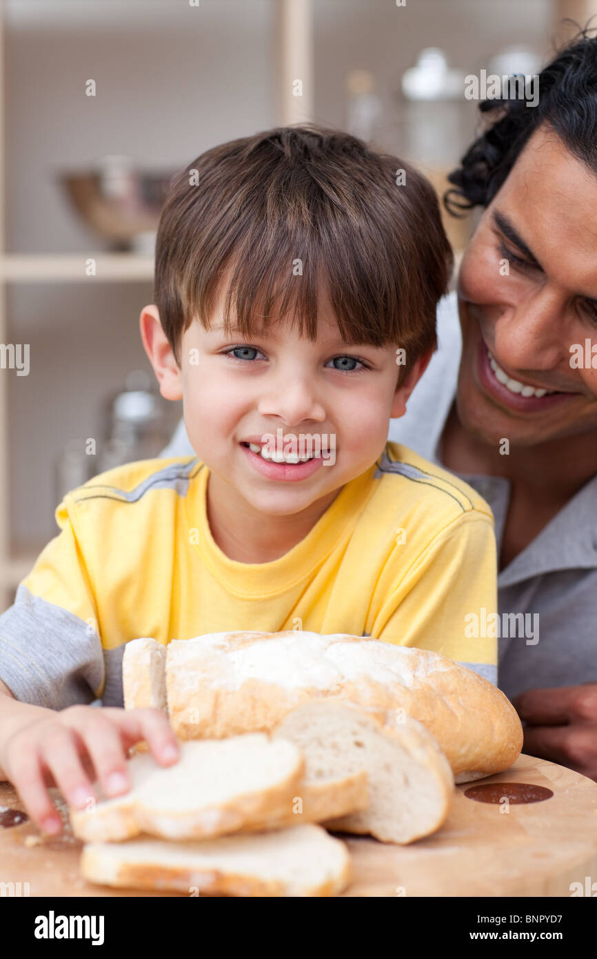 Smiling child eating bread with his father Stock Photo - Alamy