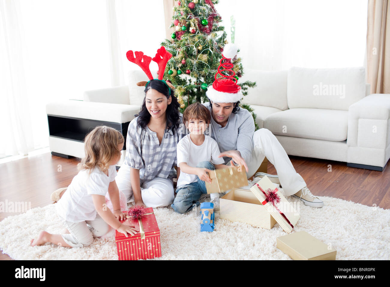 Happy family opening Christmas presents Stock Photo - Alamy