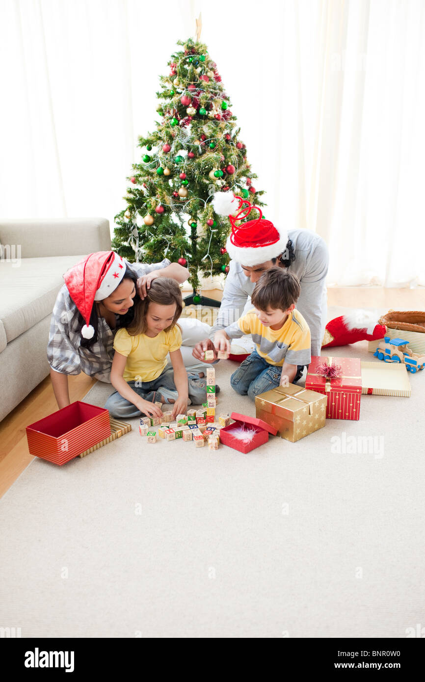 Family decorating a Christmas tree Stock Photo - Alamy