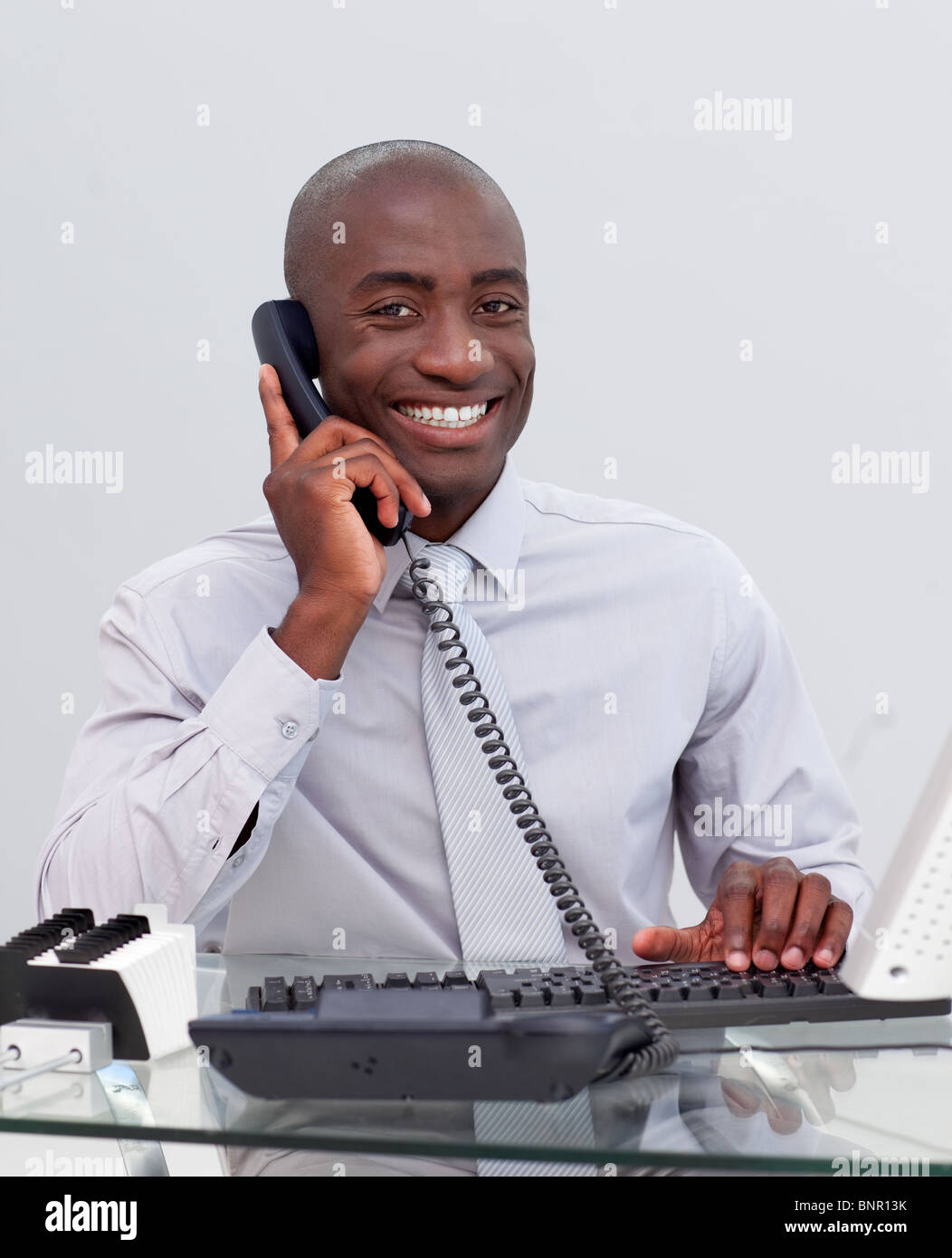 Smiling businessman on phone in the office Stock Photo - Alamy