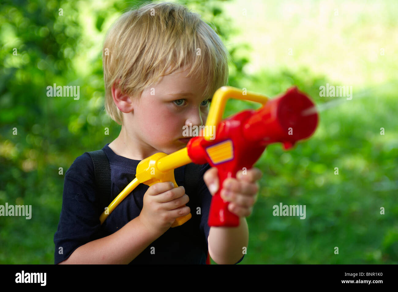 Young child boy playing fire fighter garden outside Stock Photo - Alamy
