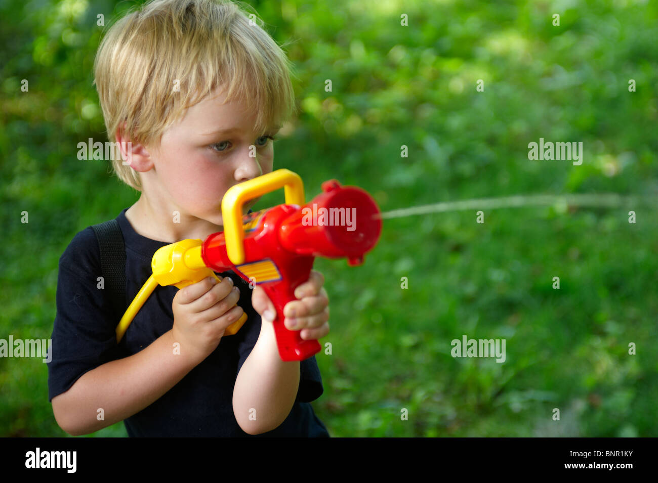 Young child boy playing fire fighter garden outside Stock Photo - Alamy