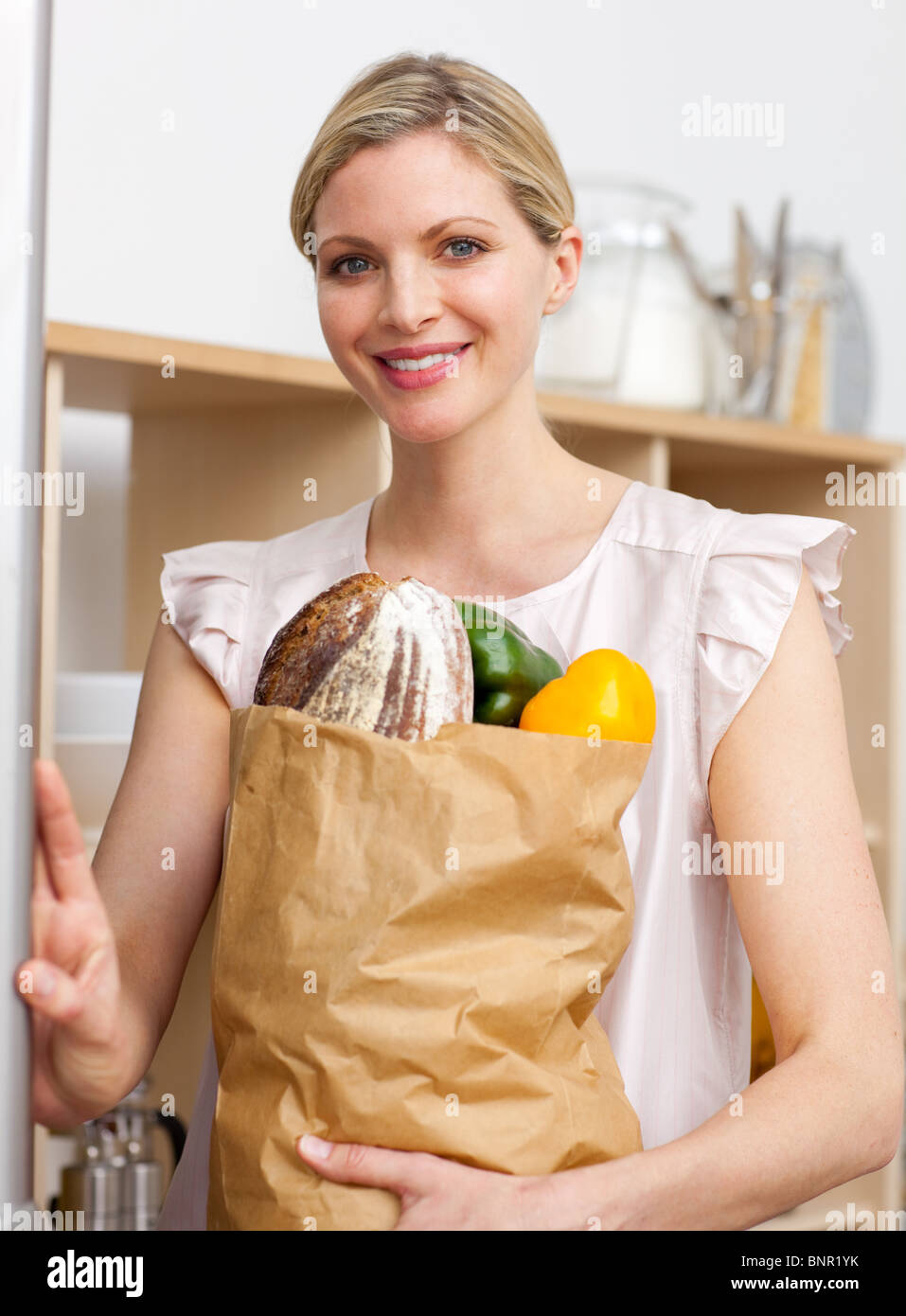 Attractive woman holding a grocery bag Stock Photo - Alamy