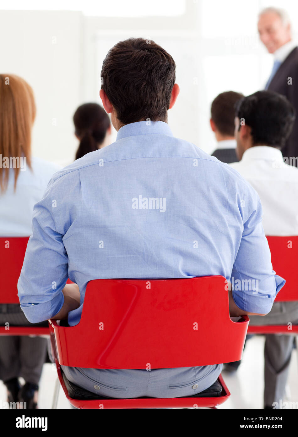 Businessman from behind at a conference Stock Photo - Alamy
