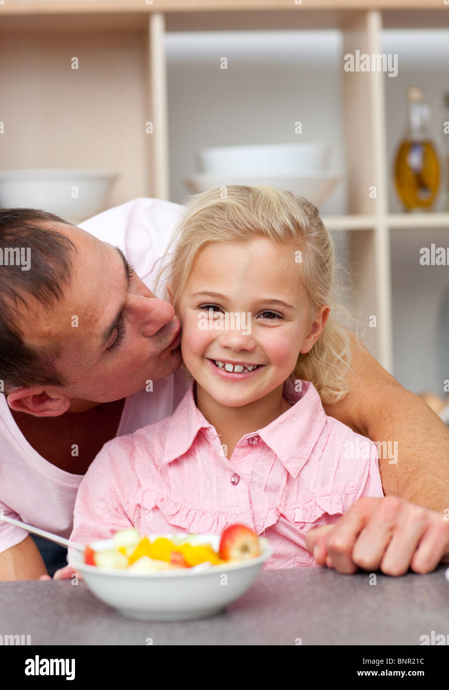 Caring father eating fruit with his daughter Stock Photo - Alamy