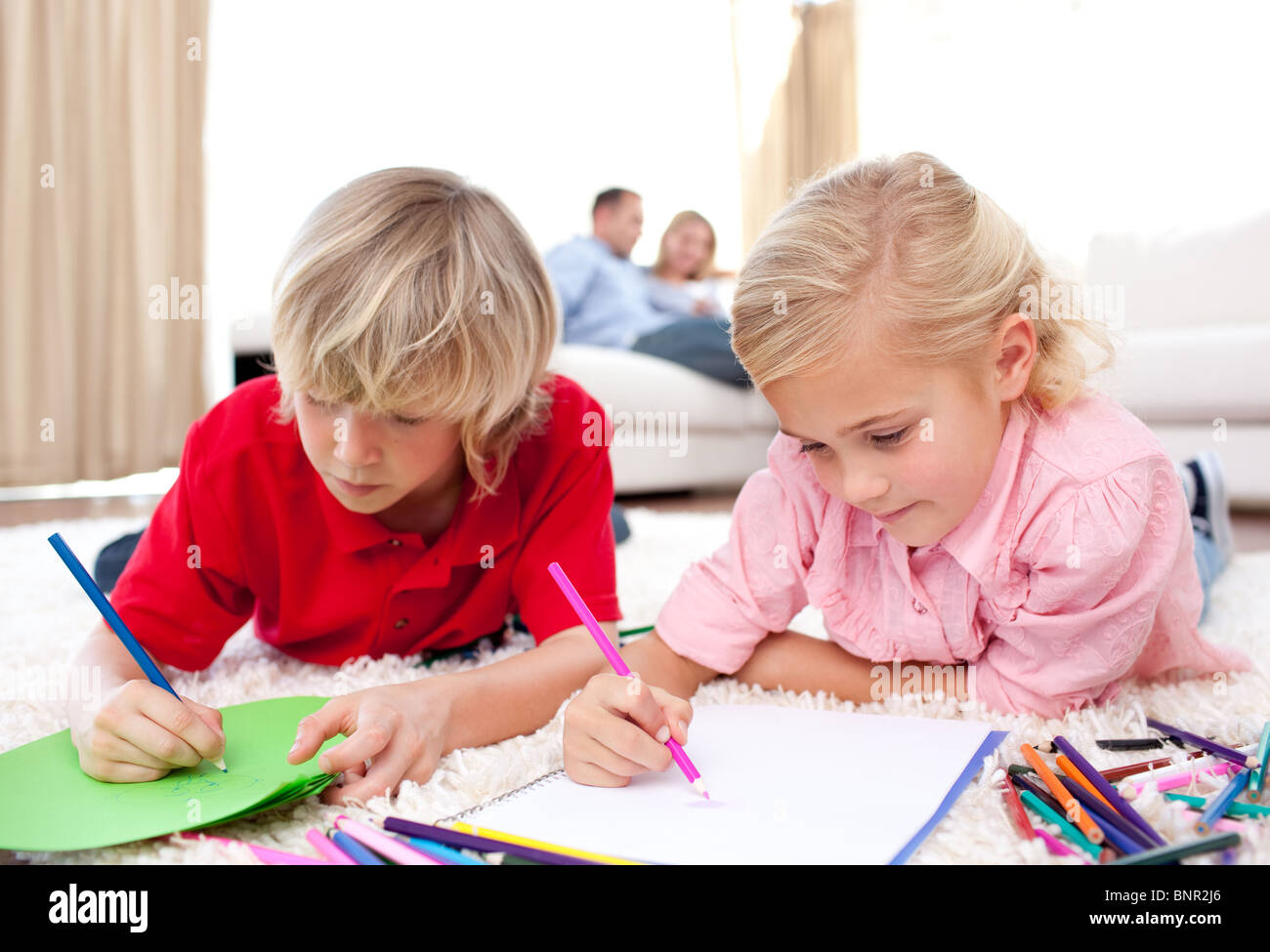 Cute siblings drawing lying on the floor Stock Photo - Alamy