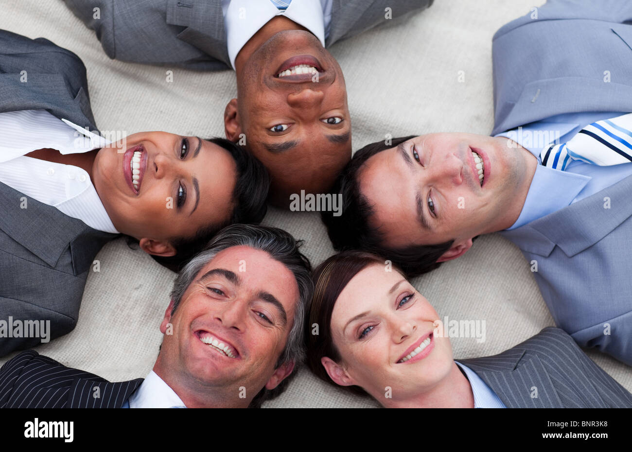 Business team lying on the floor with heads together Stock Photo - Alamy