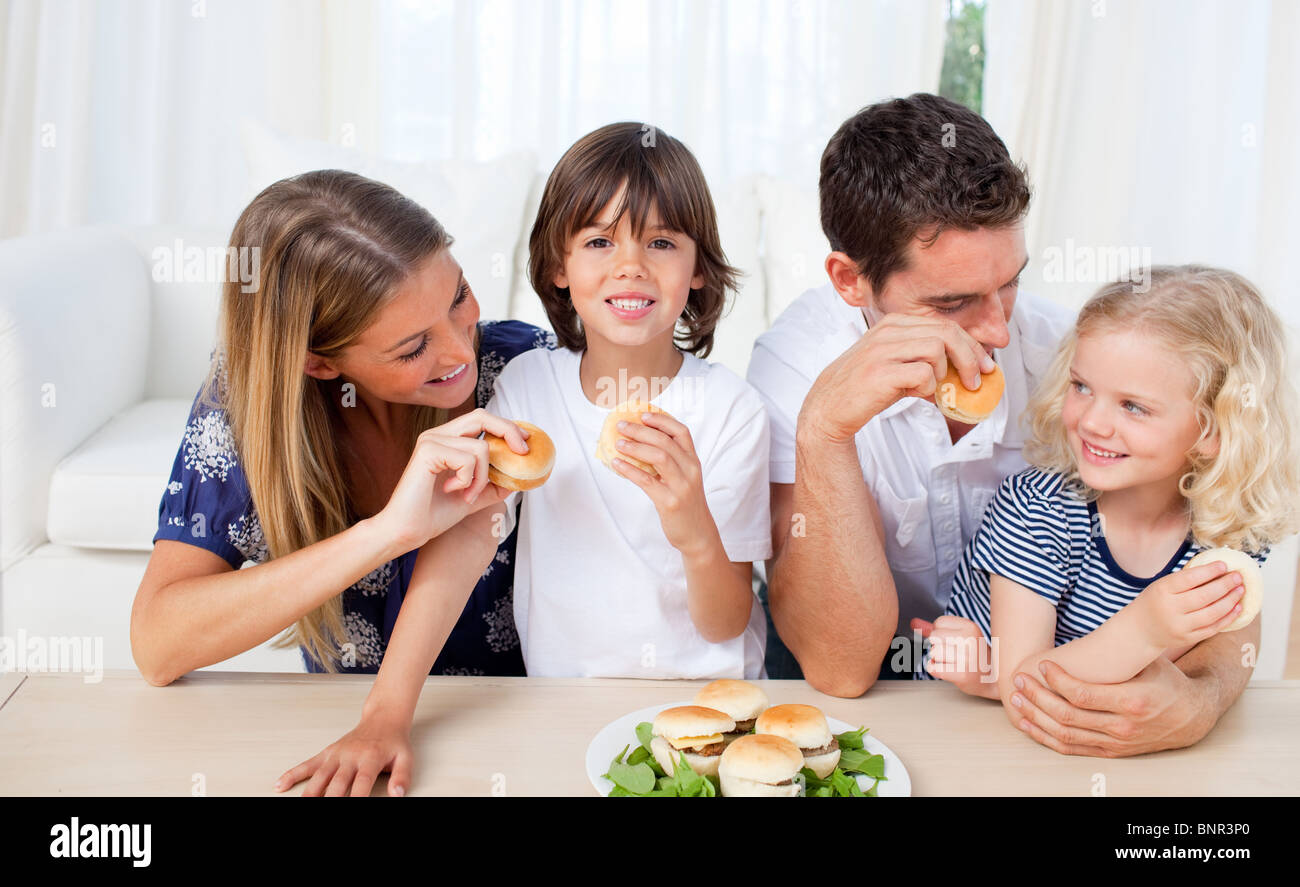 Loving family eating burgers in the living room Stock Photo - Alamy