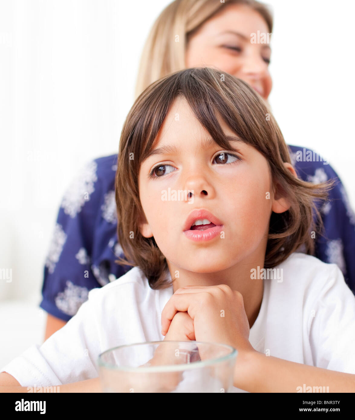 Captivated child watching television with his mother Stock Photo - Alamy