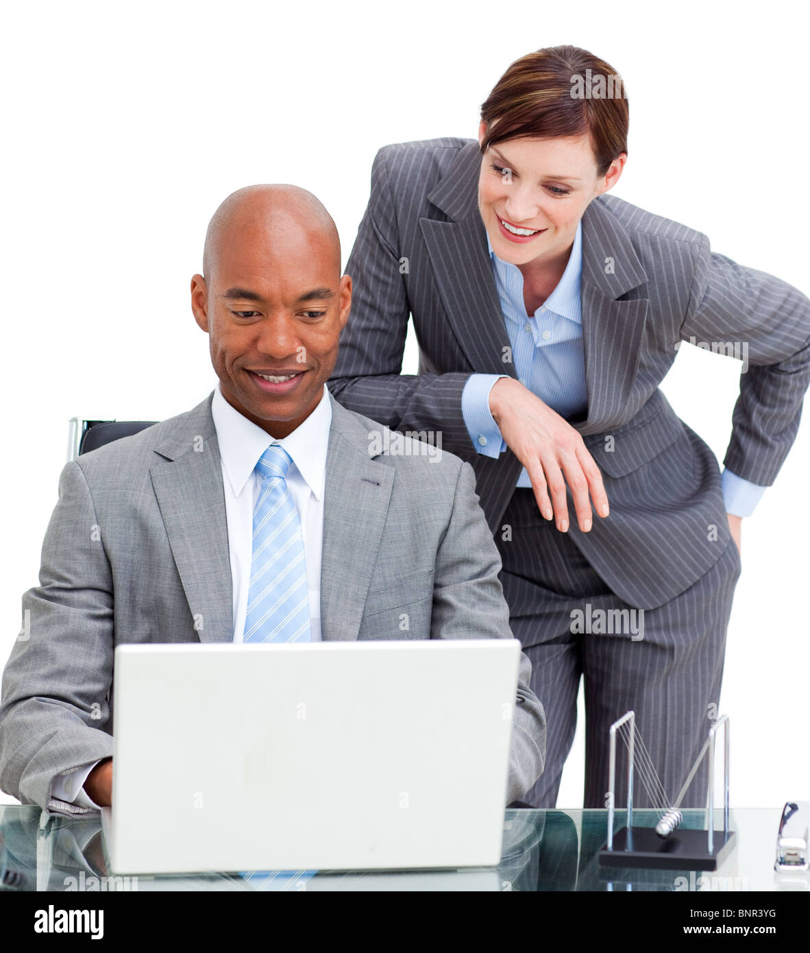 Brunette manager assisting her colleague at a computer Stock Photo - Alamy