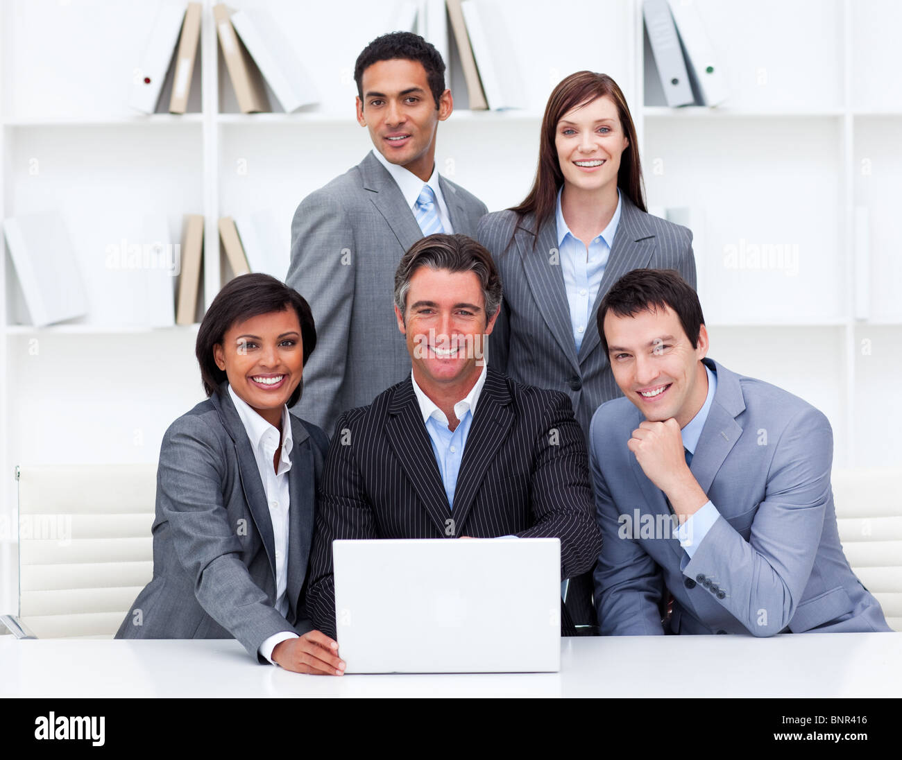 Successful business team looking at a laptop Stock Photo - Alamy