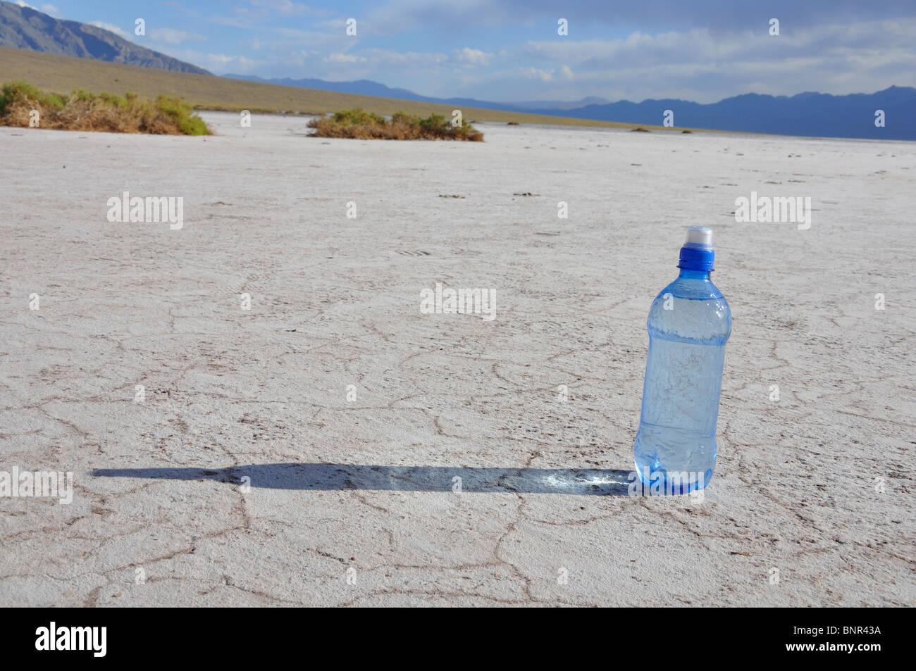 Bottle of water in desert Stock Photo - Alamy
