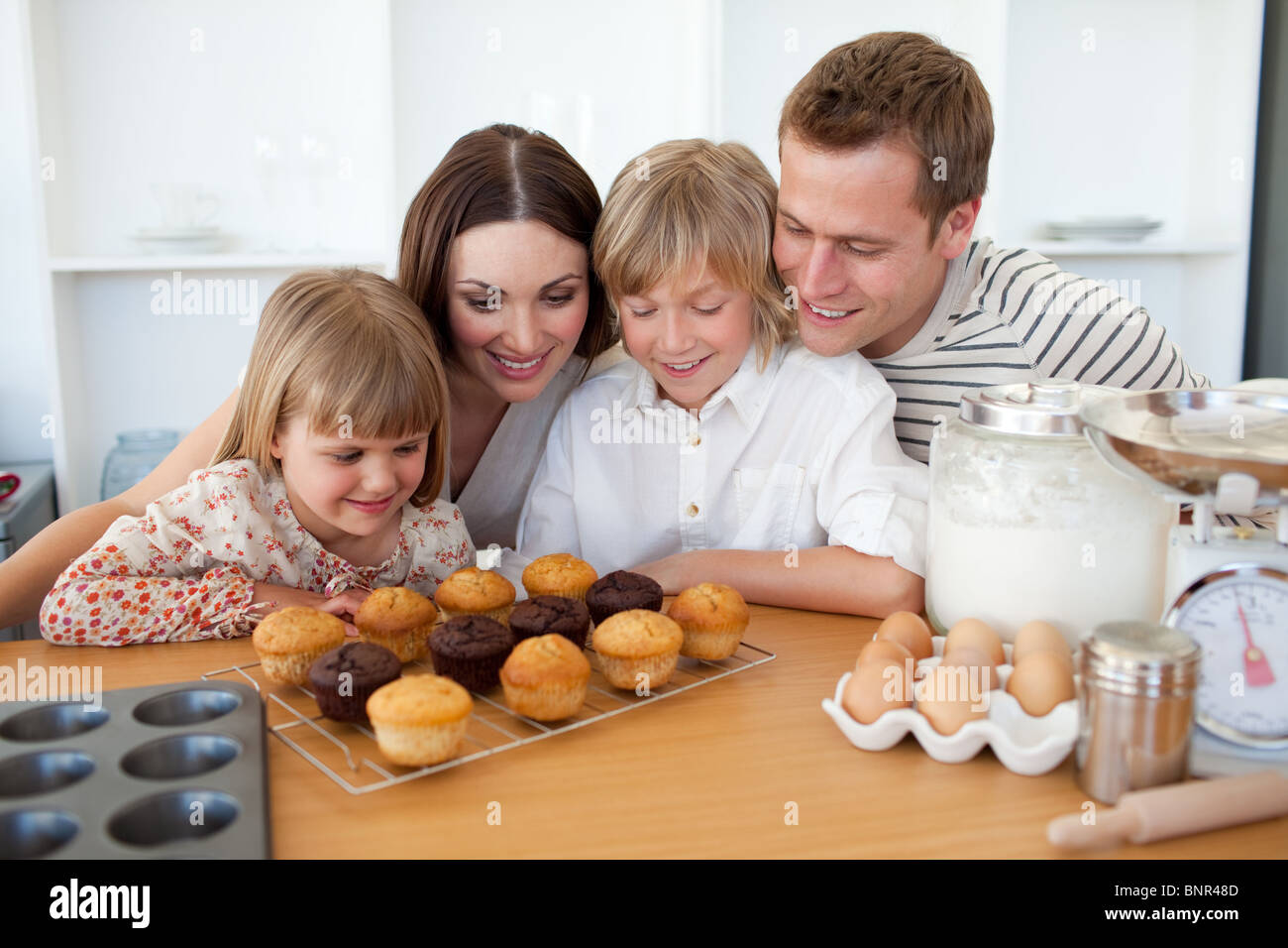 Jolly family presenting their muffins Stock Photo - Alamy