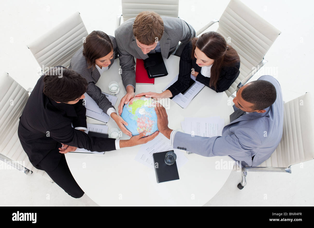 Internatonal Business team holding a terrestrial globe Stock Photo - Alamy